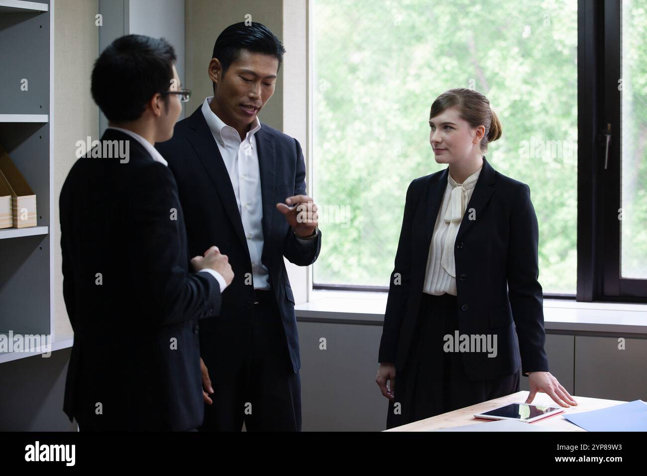 Business people talking around a desk Stock Photo - Alamy