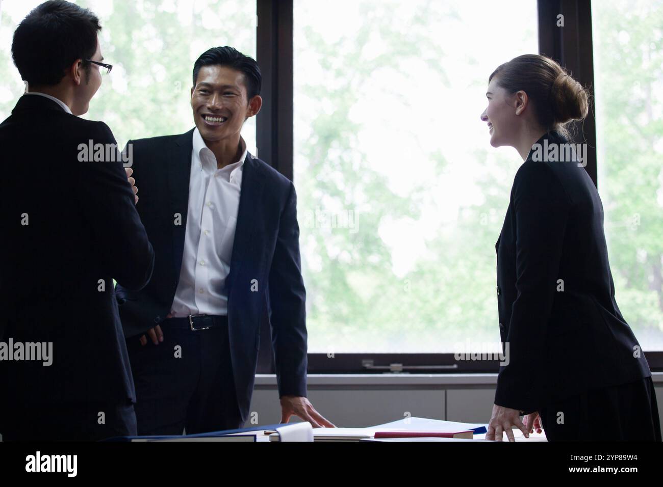 Business people talking around a desk Stock Photo - Alamy