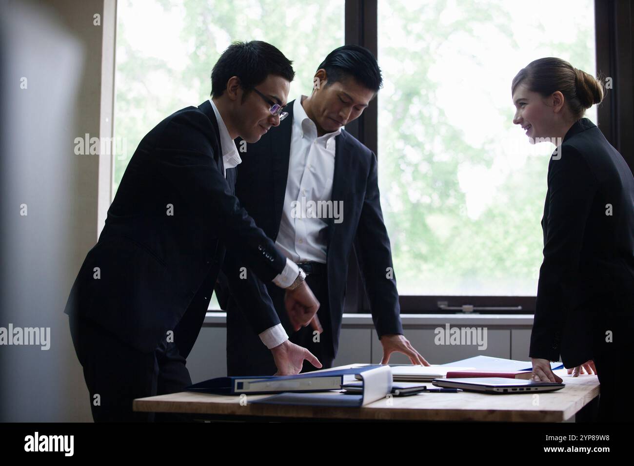 Business people talking around a desk Stock Photo - Alamy