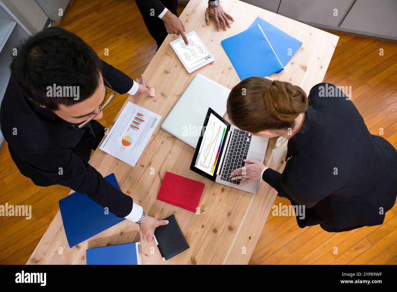 Business people talking around a desk Stock Photo - Alamy