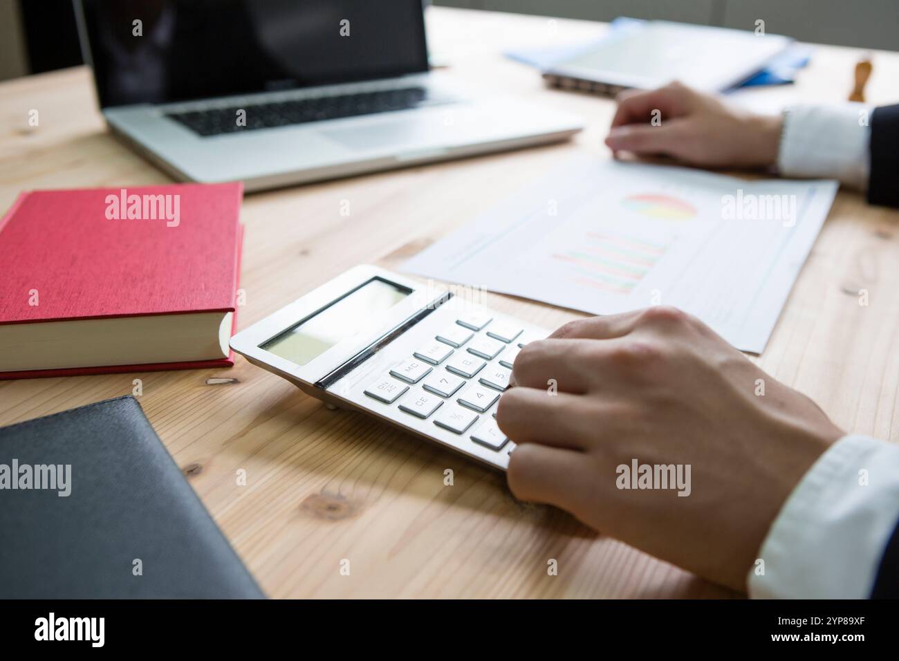 Hand tapping on calculator Stock Photo - Alamy