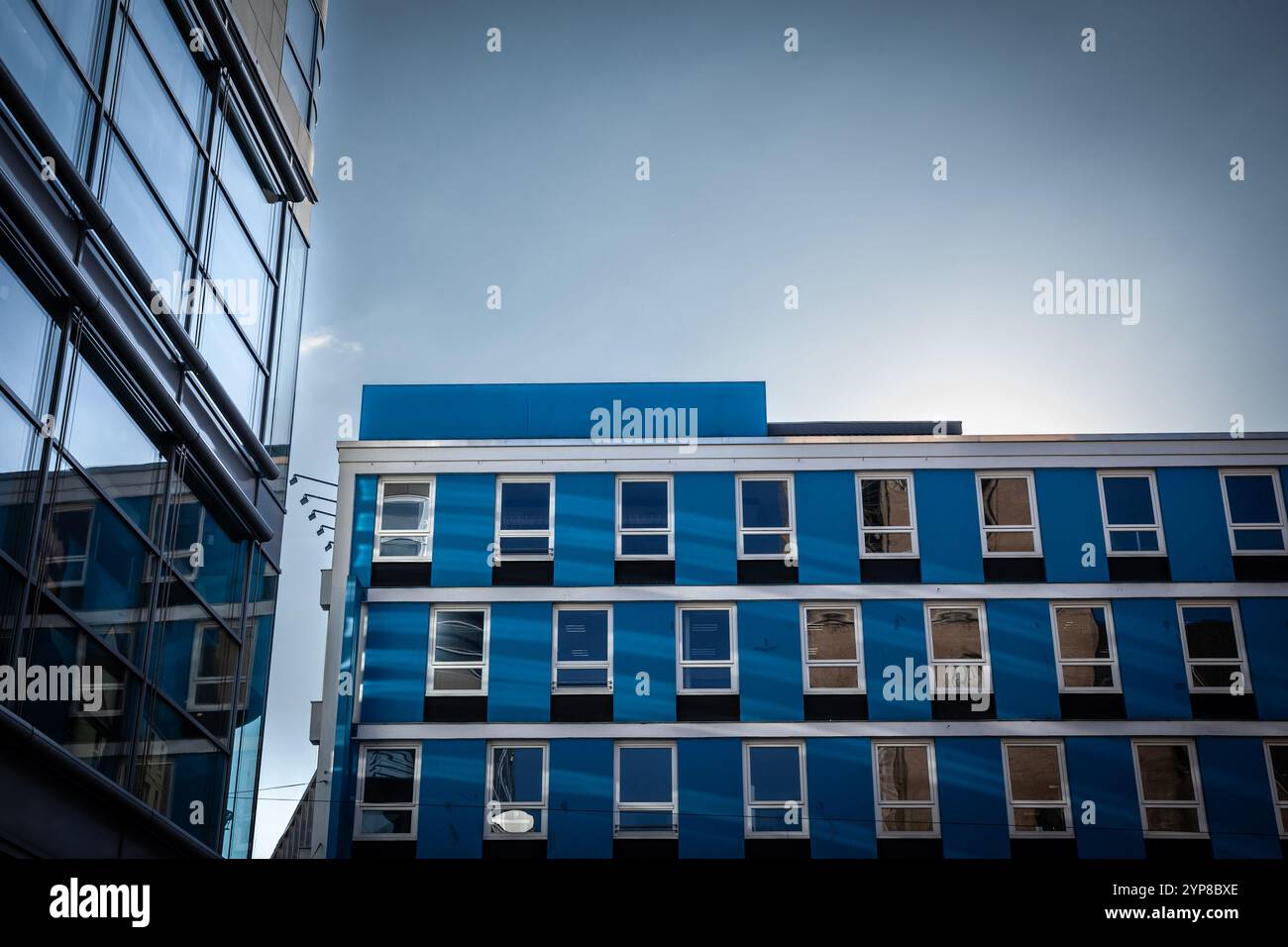 Modern business office building with a glass facade and blue panels in ...
