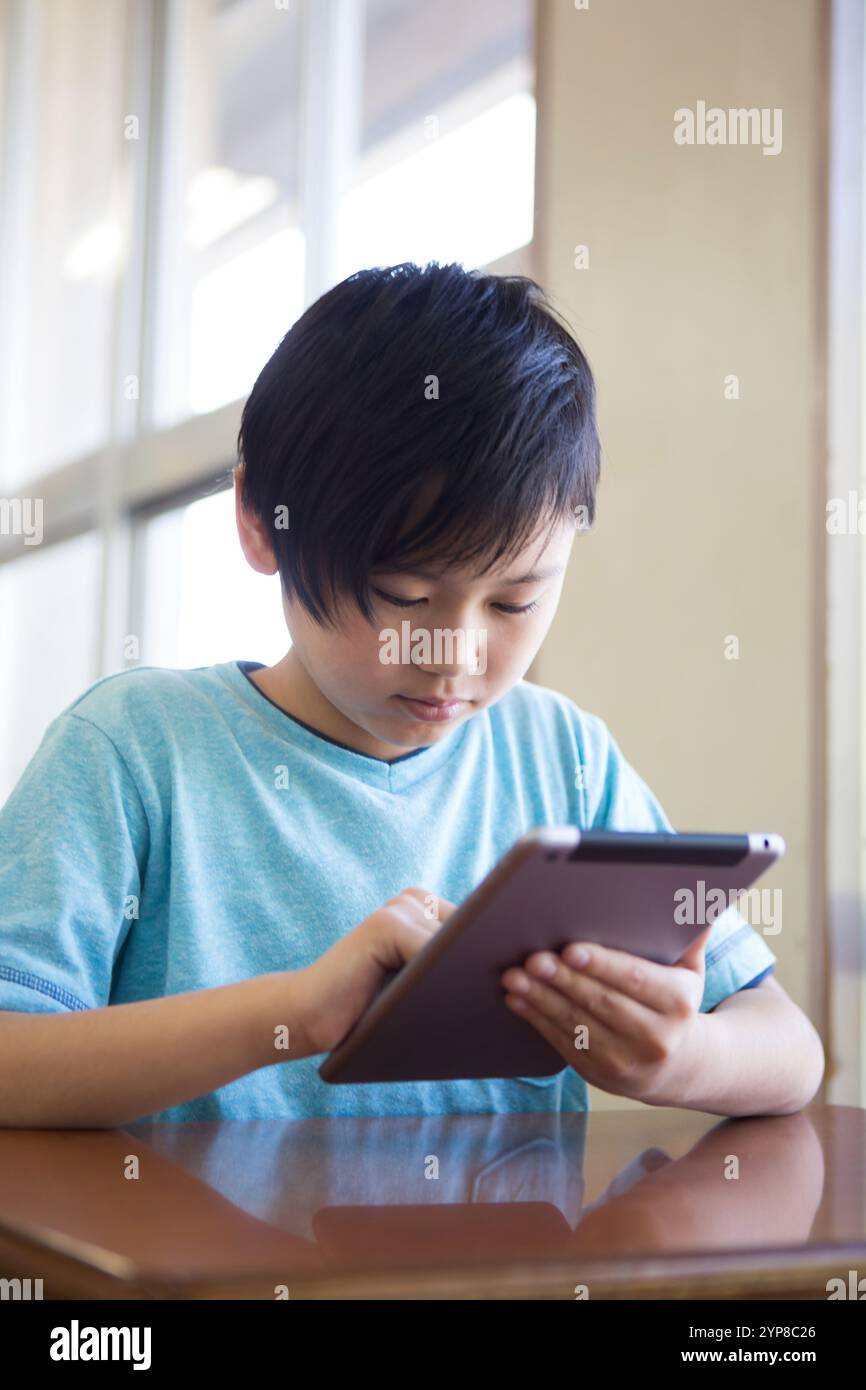 Boy using tablet Stock Photo - Alamy