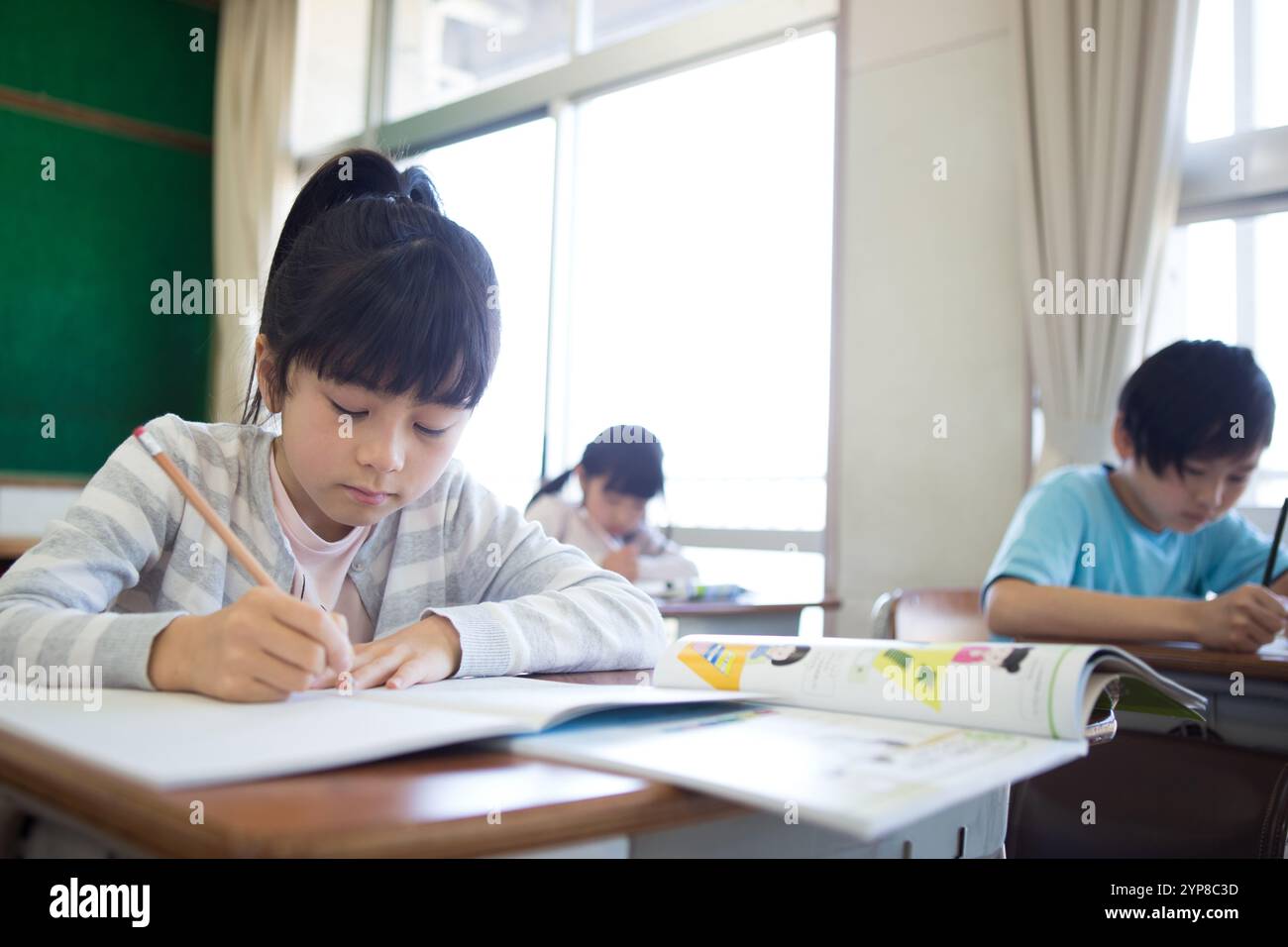 Primary schools students studying in a classroom Stock Photo - Alamy