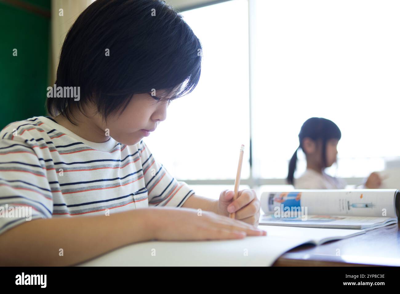 Primary schools students studying in a classroom Stock Photo - Alamy