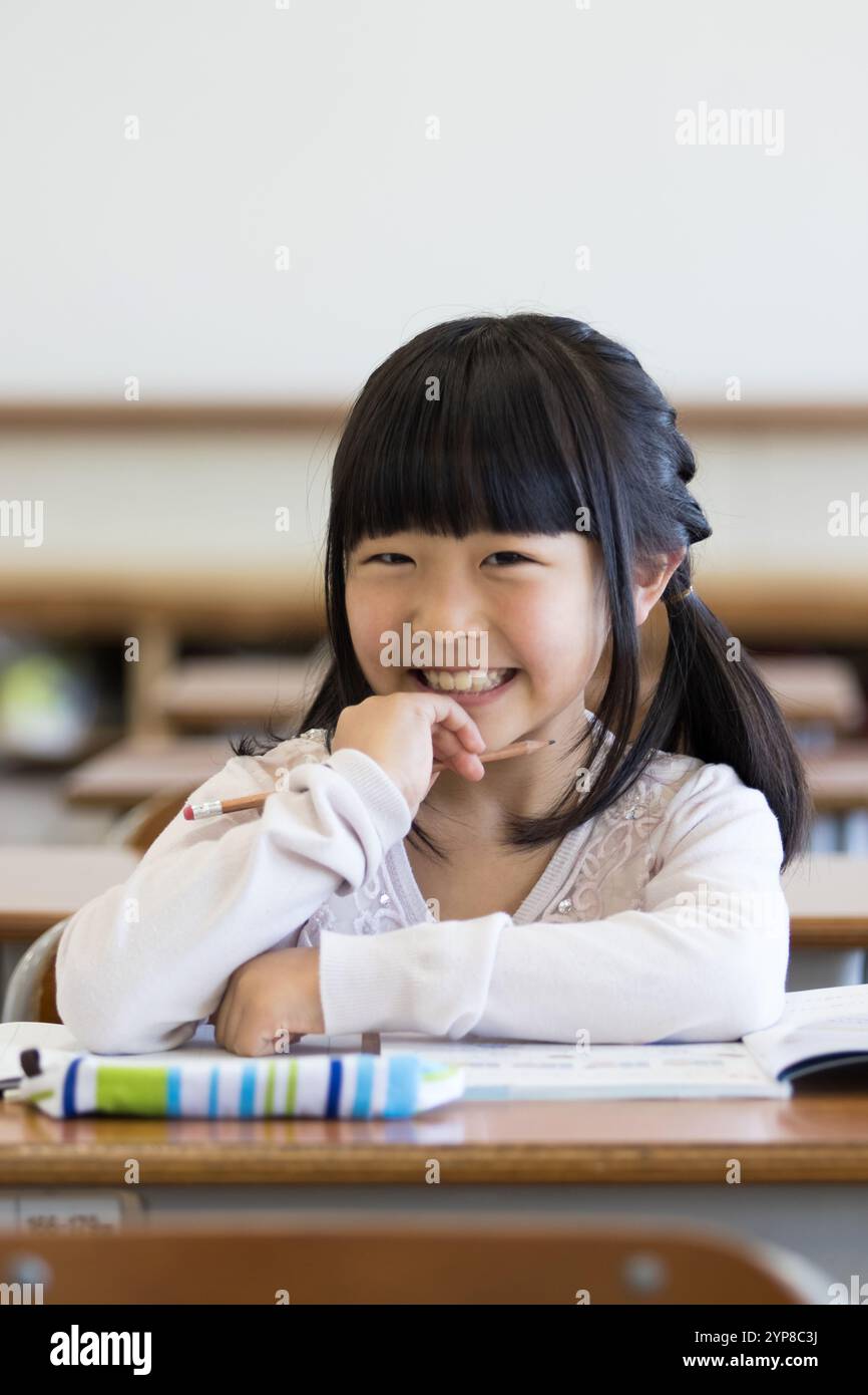 Primary schools students studying in a classroom Stock Photo - Alamy