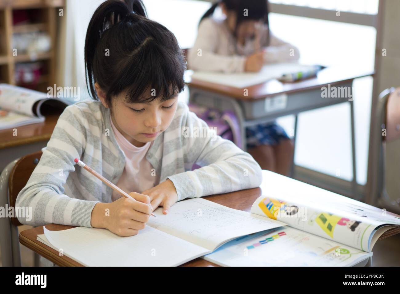 Primary schools students studying in a classroom Stock Photo - Alamy