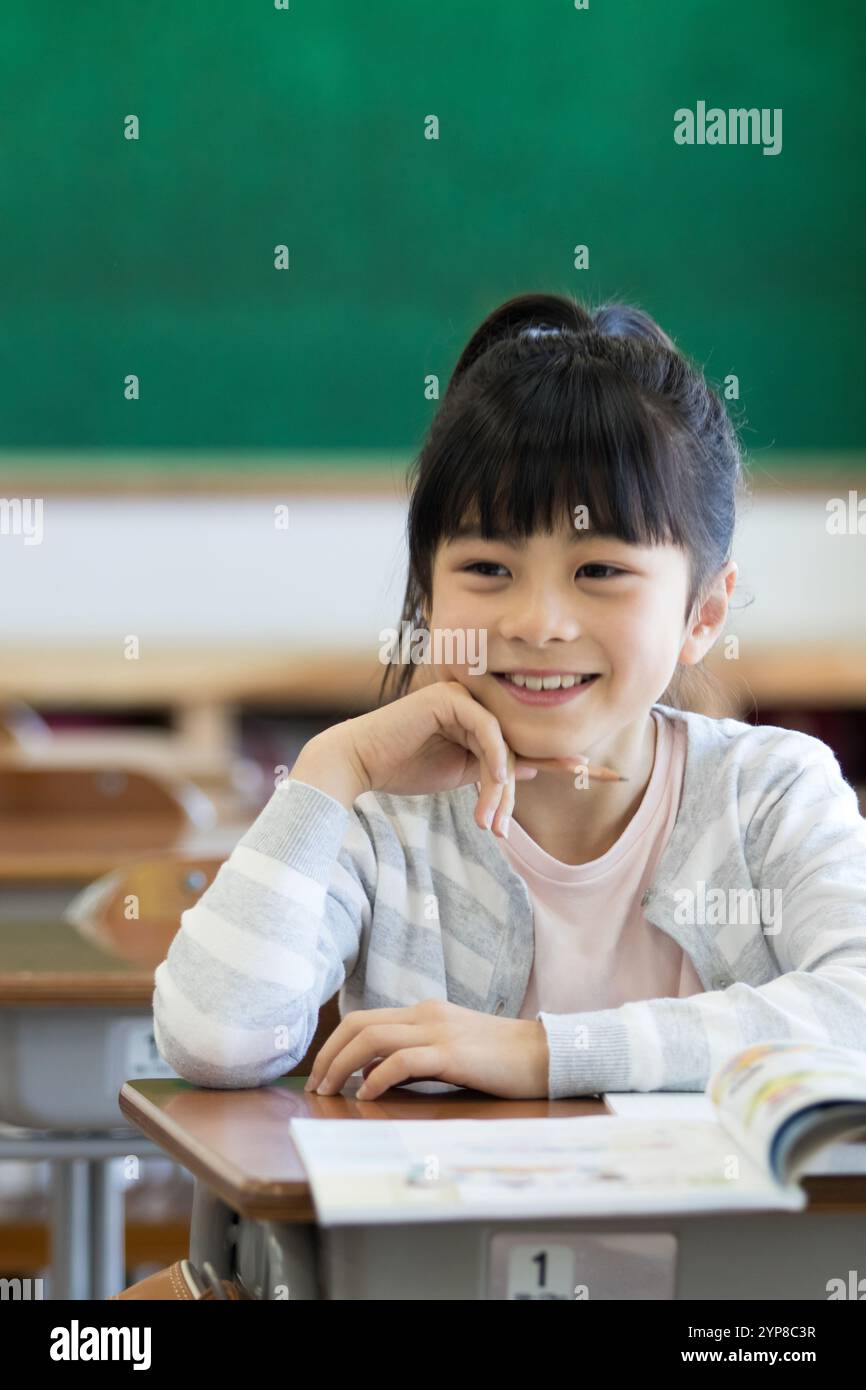 Primary schools students studying in a classroom Stock Photo - Alamy