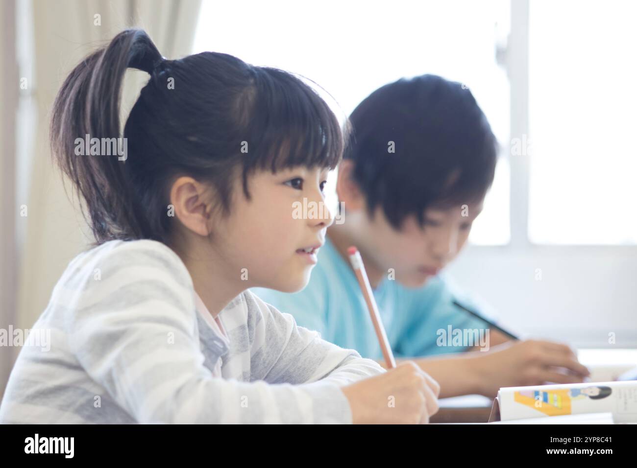 Primary schools students studying in a classroom Stock Photo - Alamy