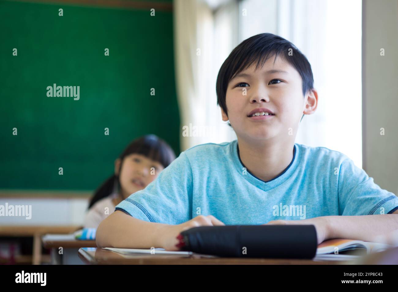 Primary schools students studying in a classroom Stock Photo - Alamy