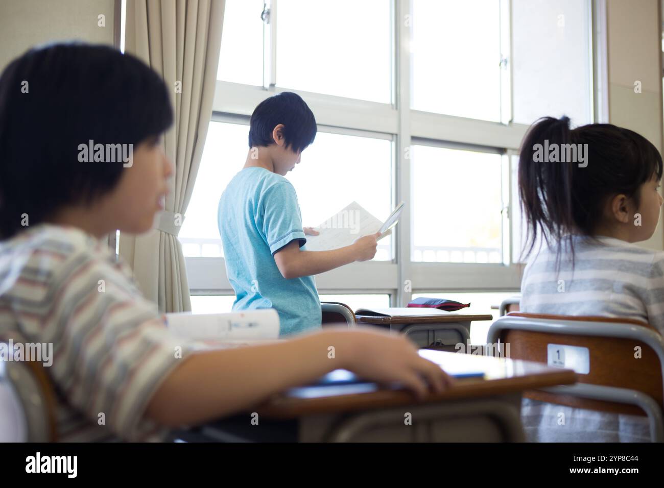Primary schools students studying in a classroom Stock Photo - Alamy