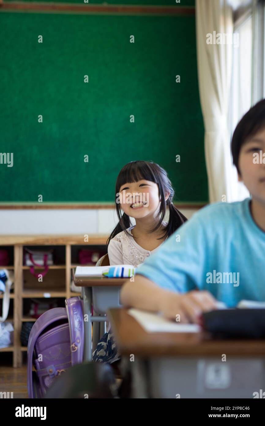 Primary schools students studying in a classroom Stock Photo - Alamy