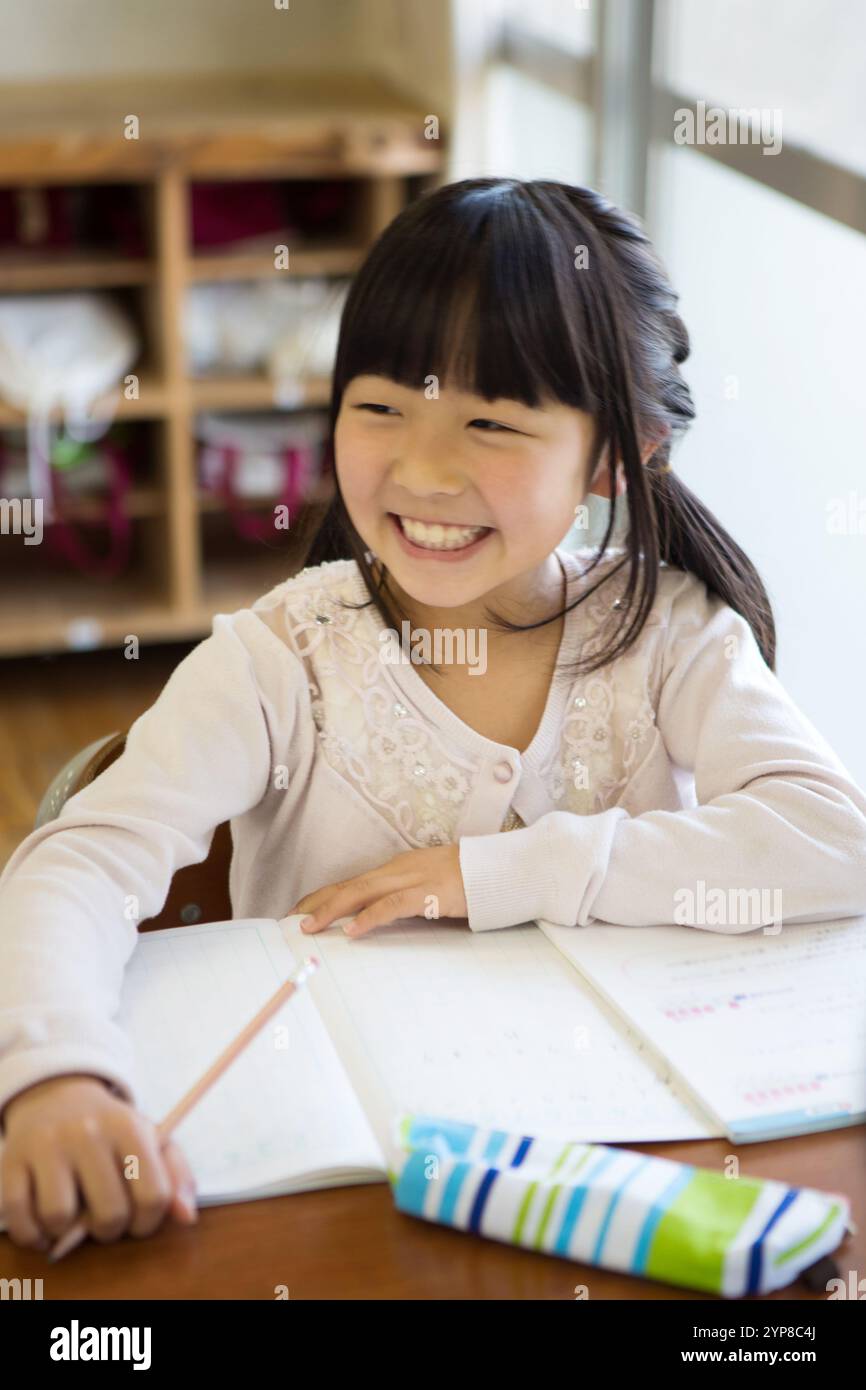 Primary schools students studying in a classroom Stock Photo - Alamy