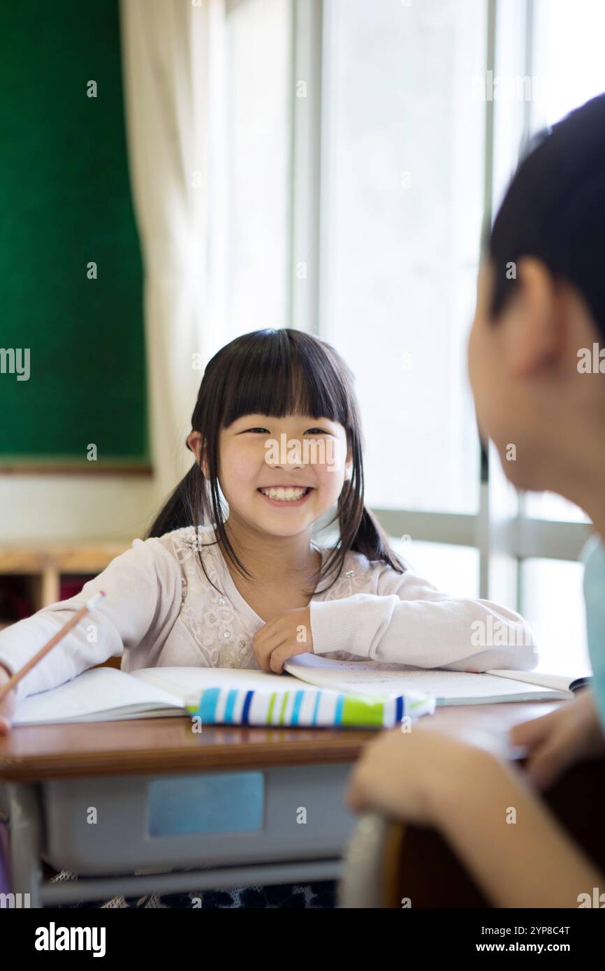 Primary schools students studying in a classroom Stock Photo - Alamy