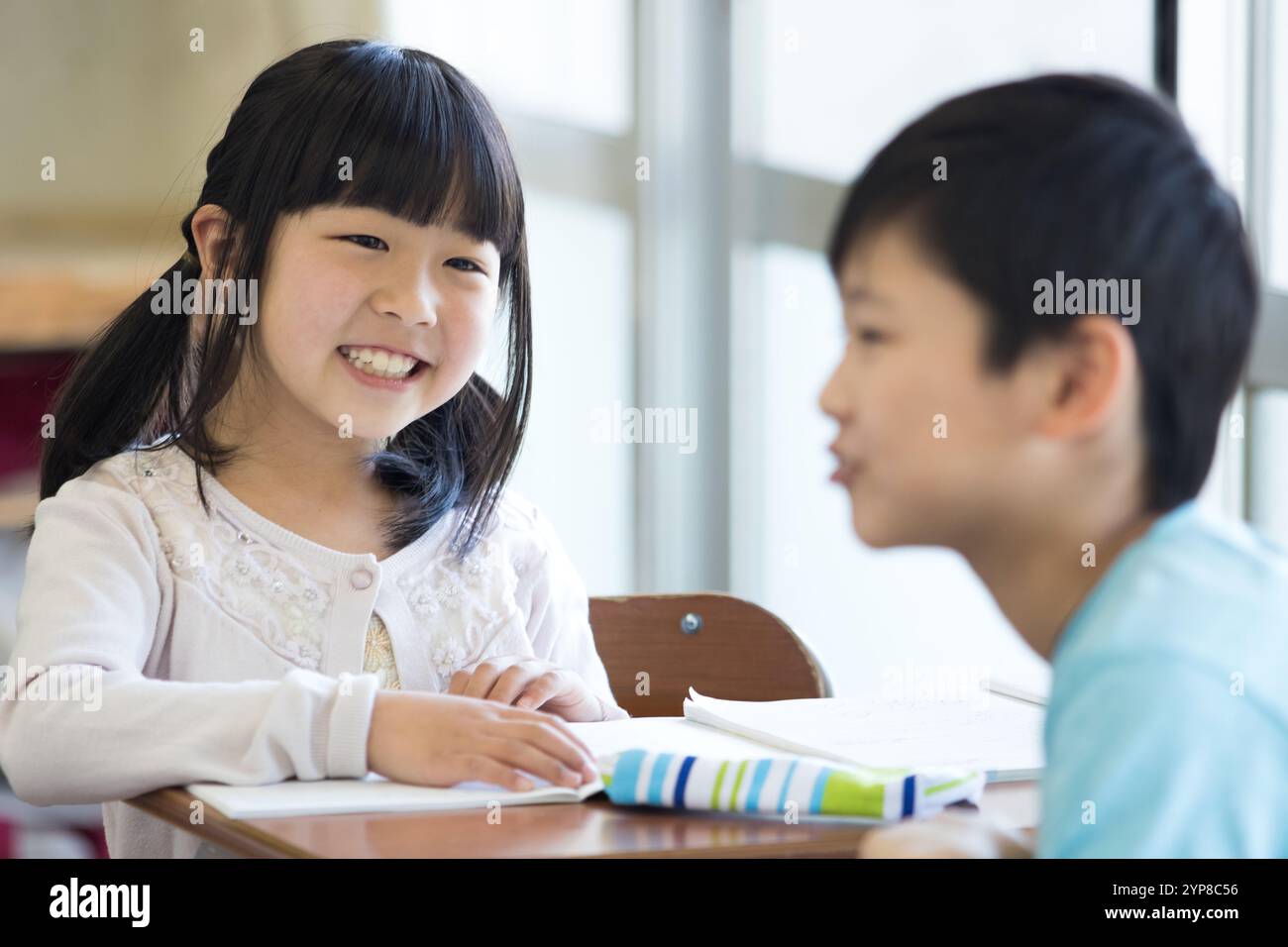 Primary schools students chatting in classroom Stock Photo - Alamy