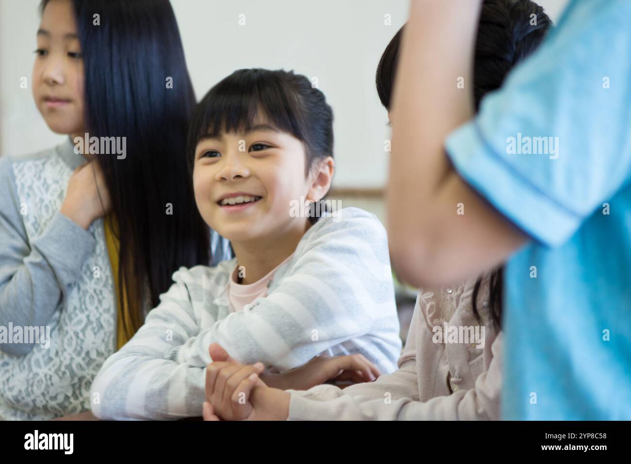 Primary schools students chatting in classroom Stock Photo - Alamy