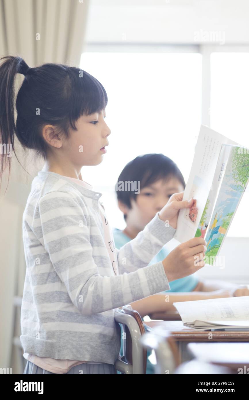 Primary schools students studying in a classroom Stock Photo - Alamy