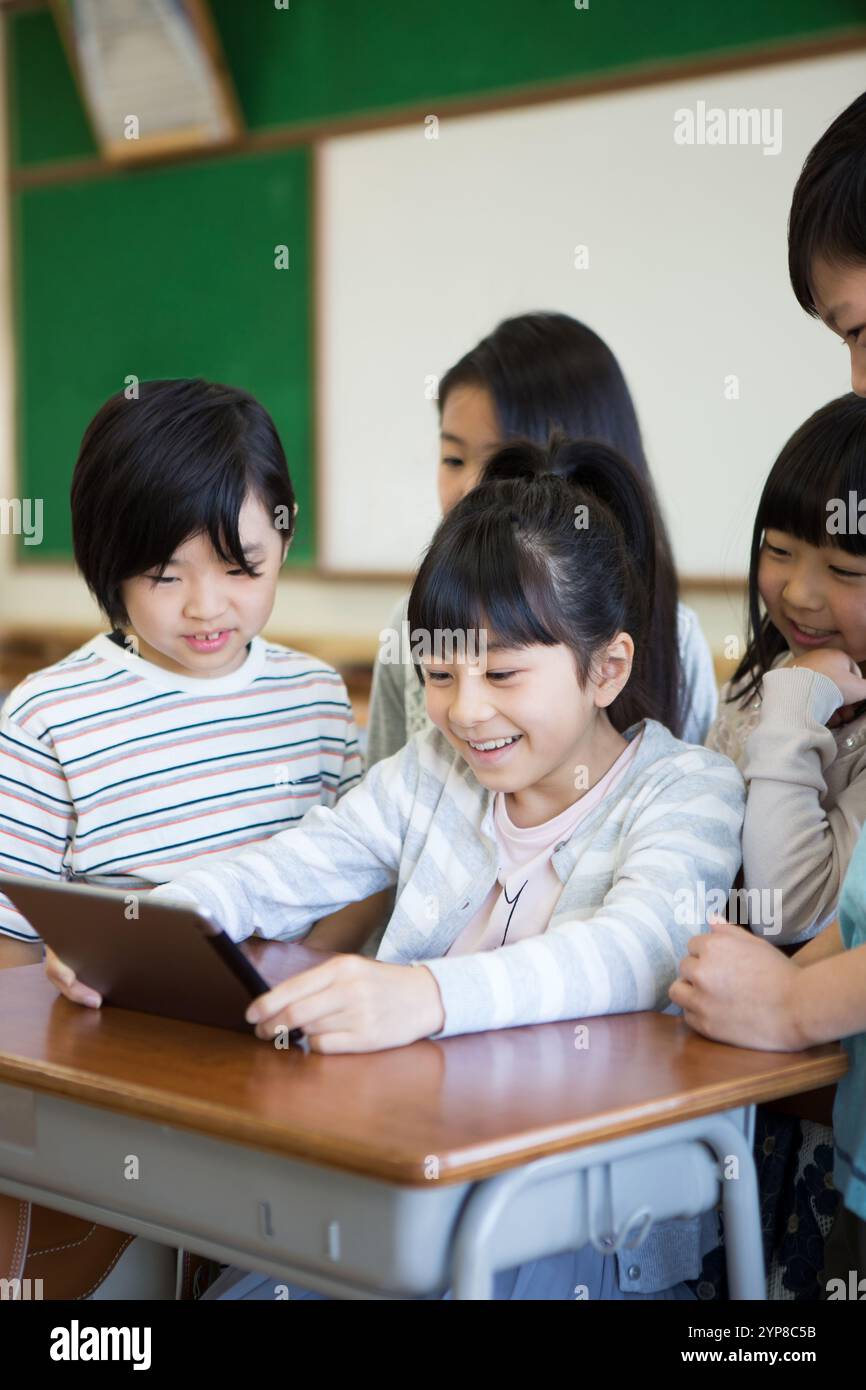 Primary school children using a tablet Stock Photo - Alamy