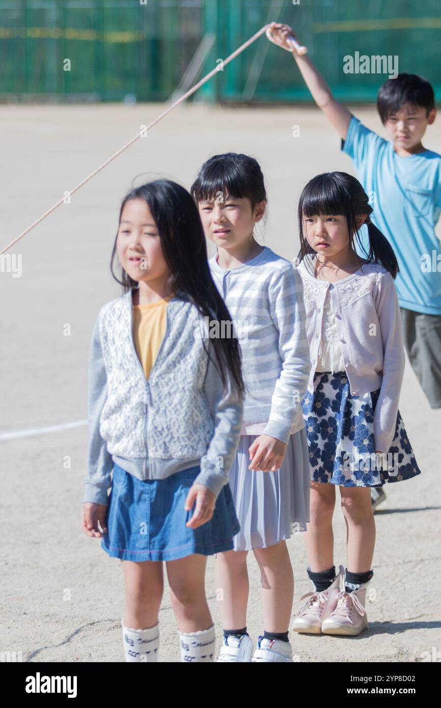Primary school children jumping rope Stock Photo - Alamy