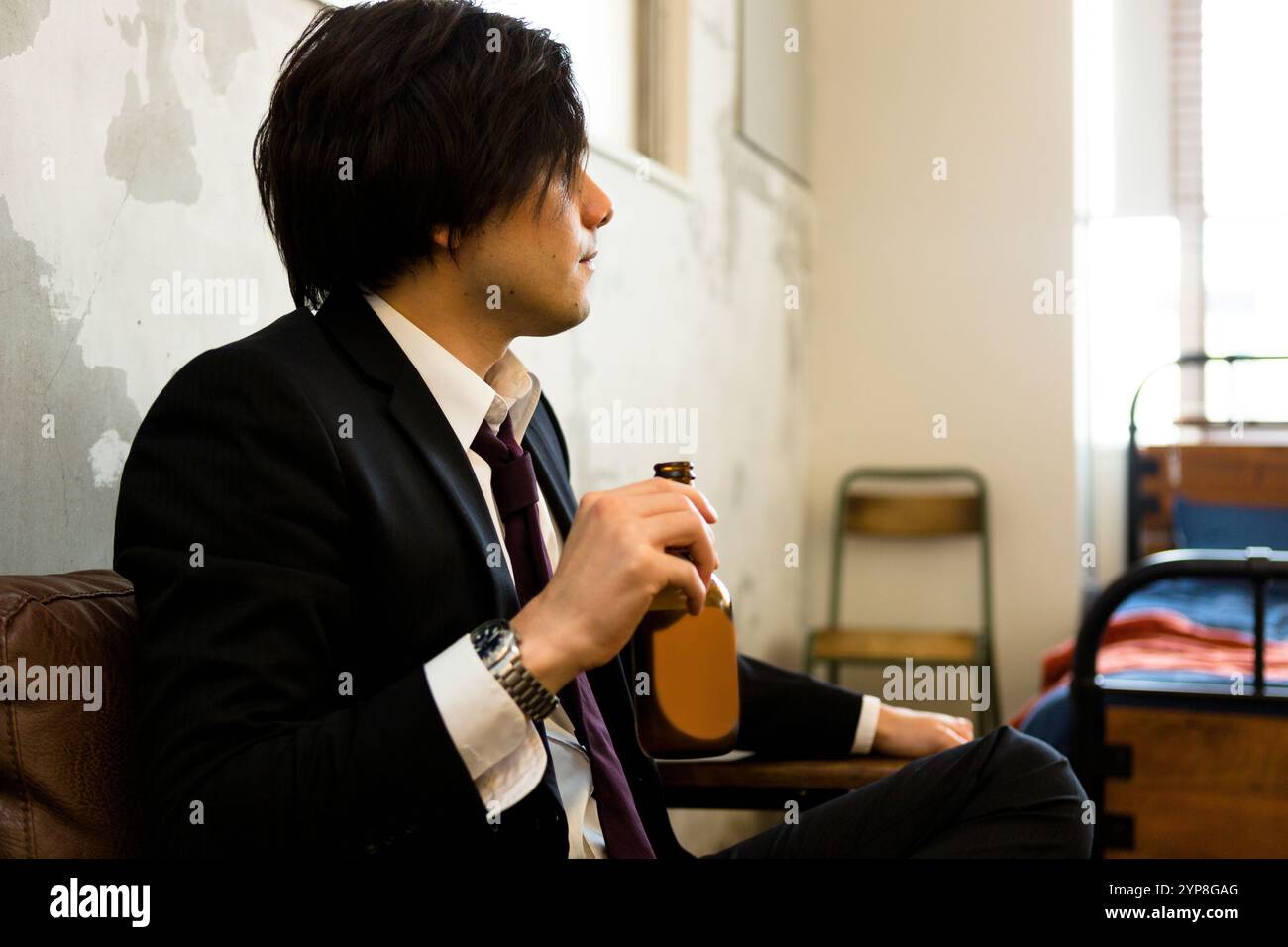 Man drinking beer on sofa Stock Photo - Alamy