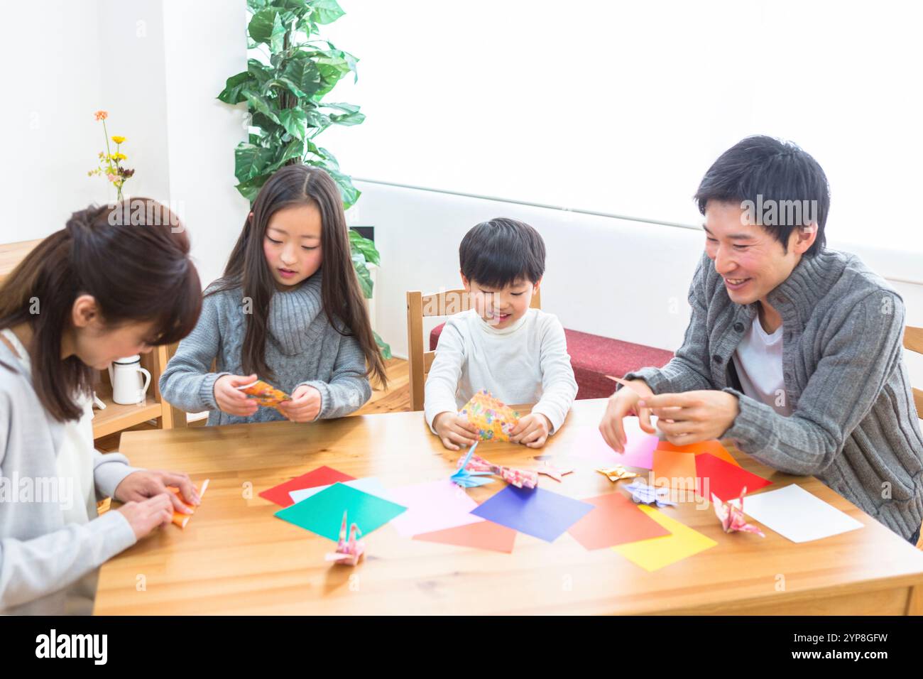 Parent and child doing Origami Stock Photo - Alamy