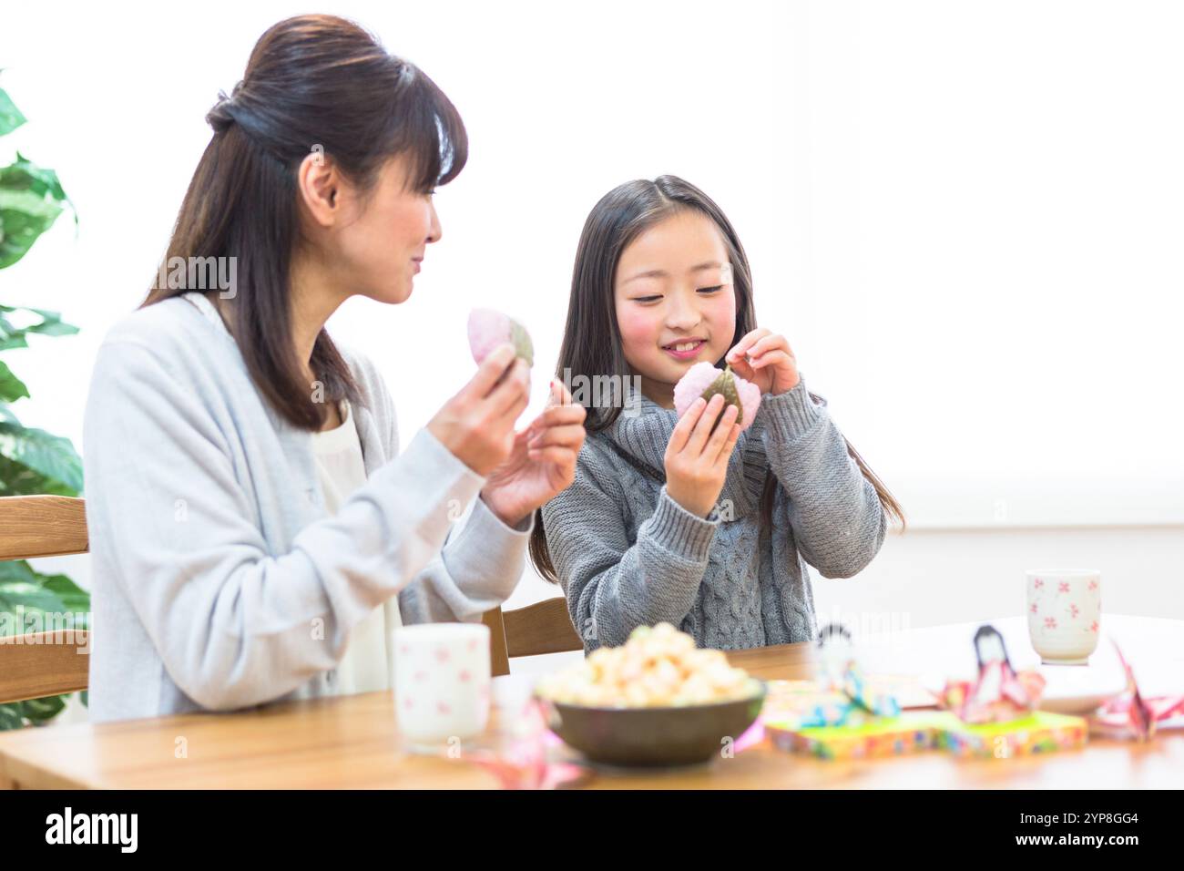 Parent and child eating sakura mochi Stock Photo - Alamy