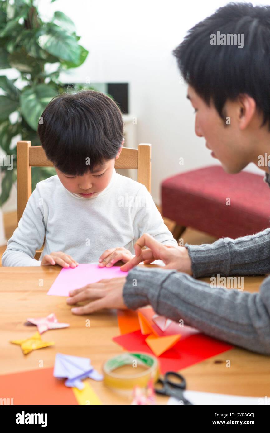 Parent and child doing Origami Stock Photo - Alamy