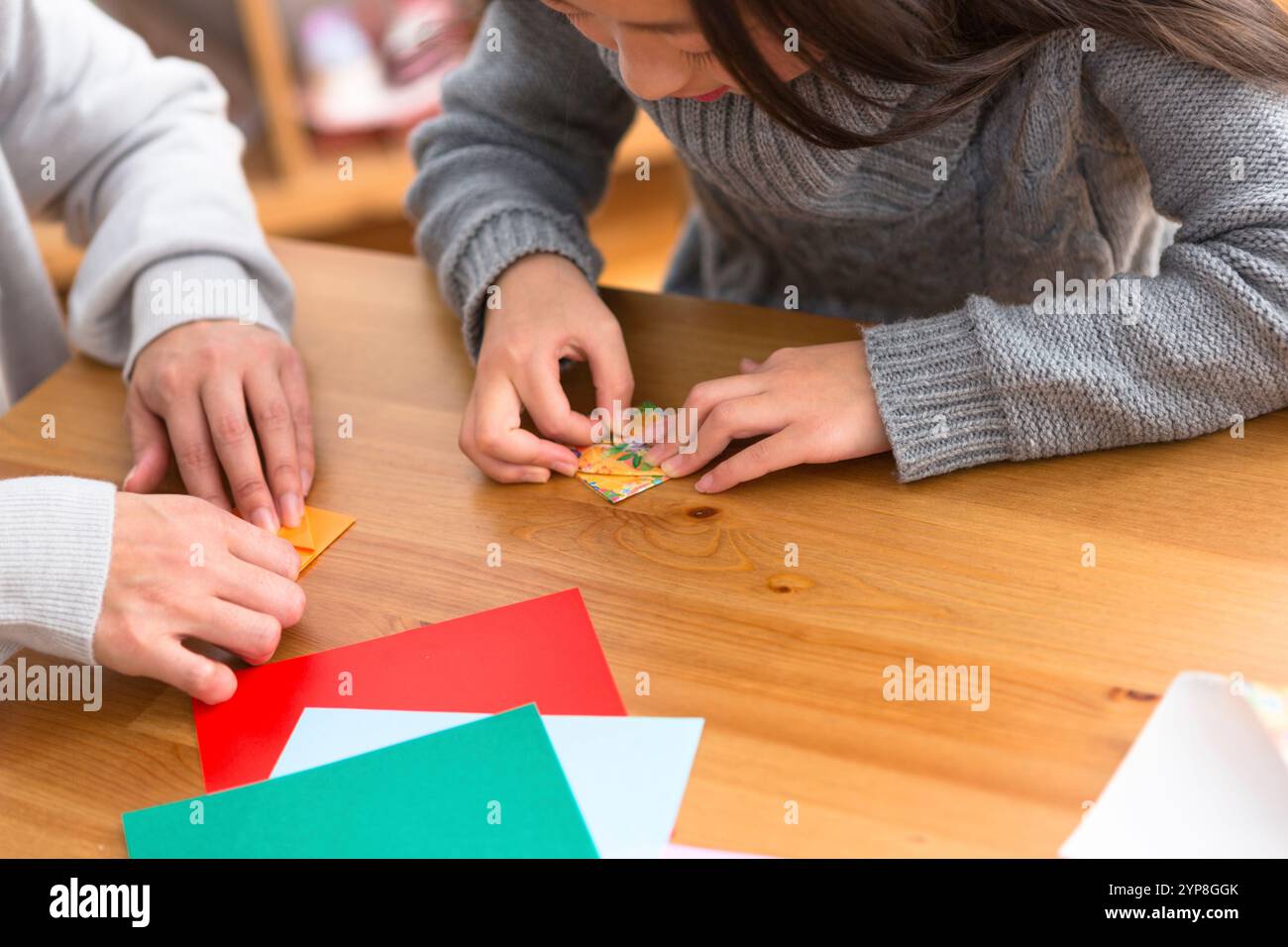 Parent and child doing Origami Stock Photo - Alamy