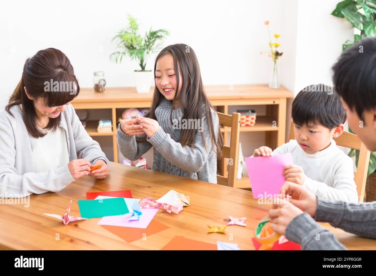 Parent and child doing Origami Stock Photo - Alamy