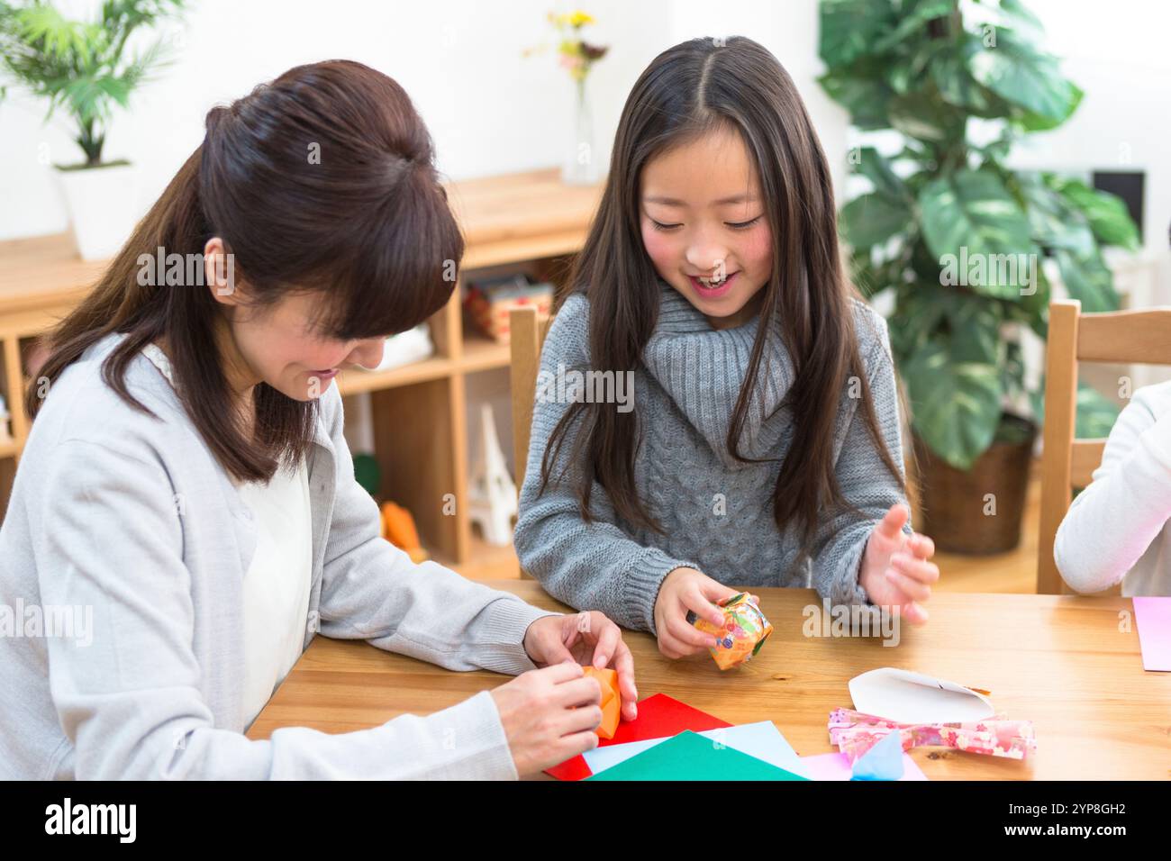 Parent and child doing Origami Stock Photo - Alamy