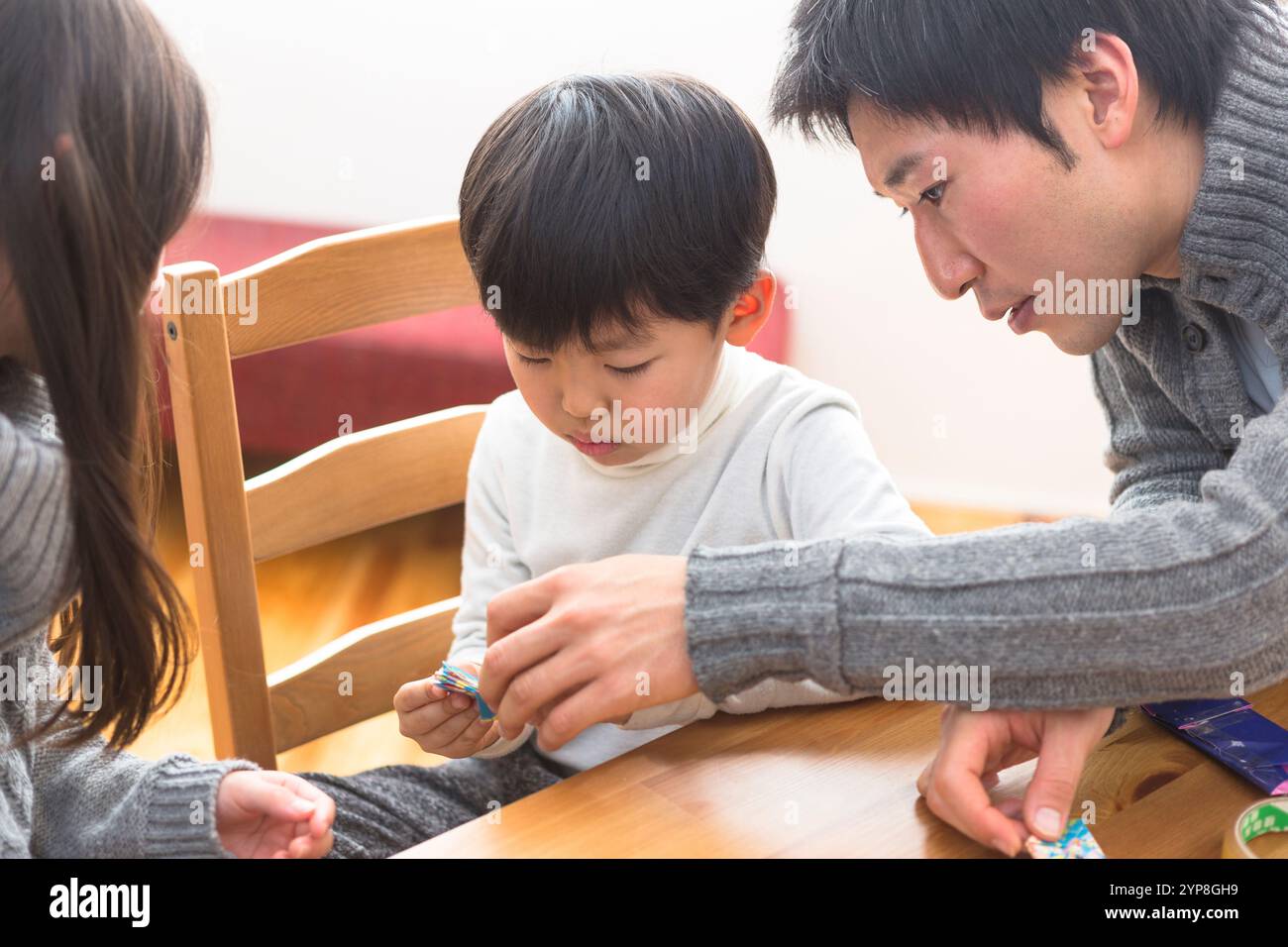 Parent and child doing Origami Stock Photo - Alamy