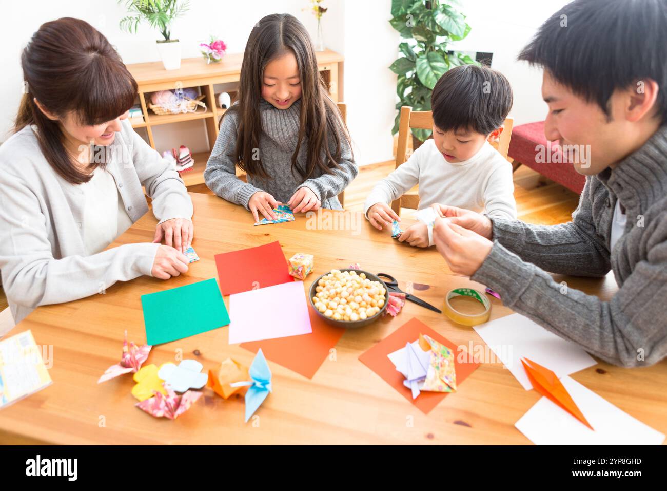 Parent and child doing Origami Stock Photo - Alamy