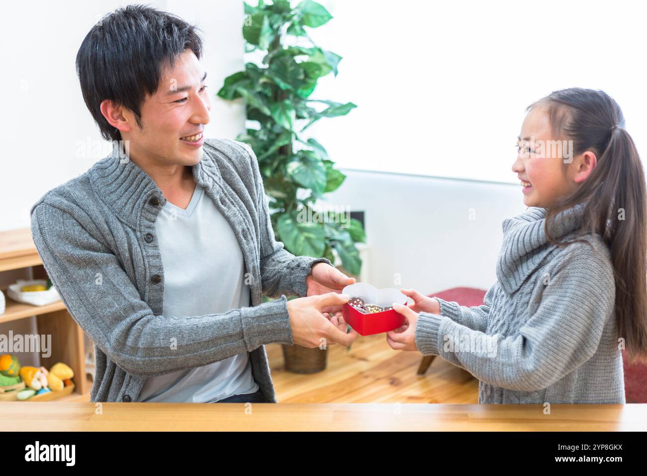 Daughter handing chocolate to father Stock Photo - Alamy