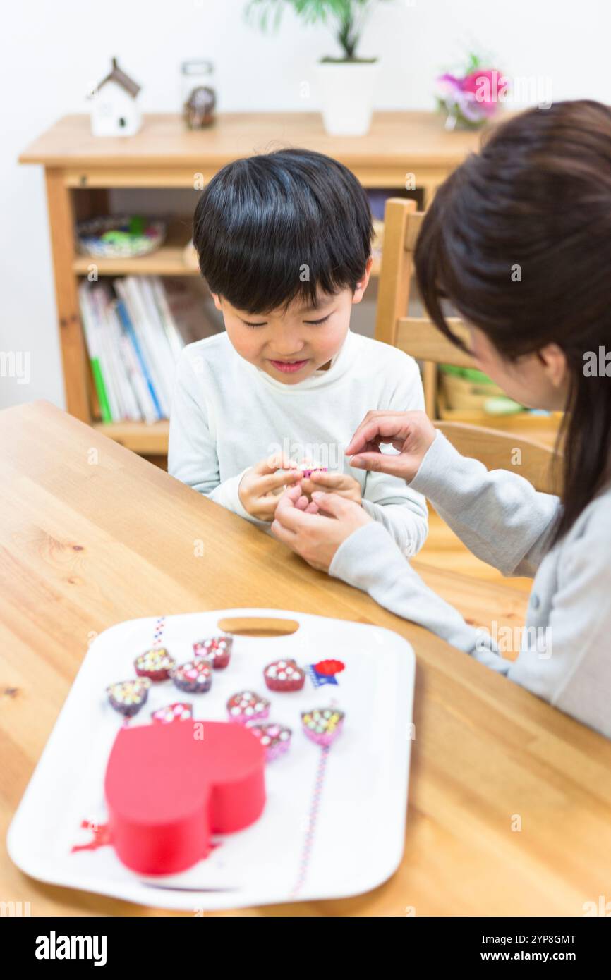 Mother giving chocolate to her son Stock Photo - Alamy