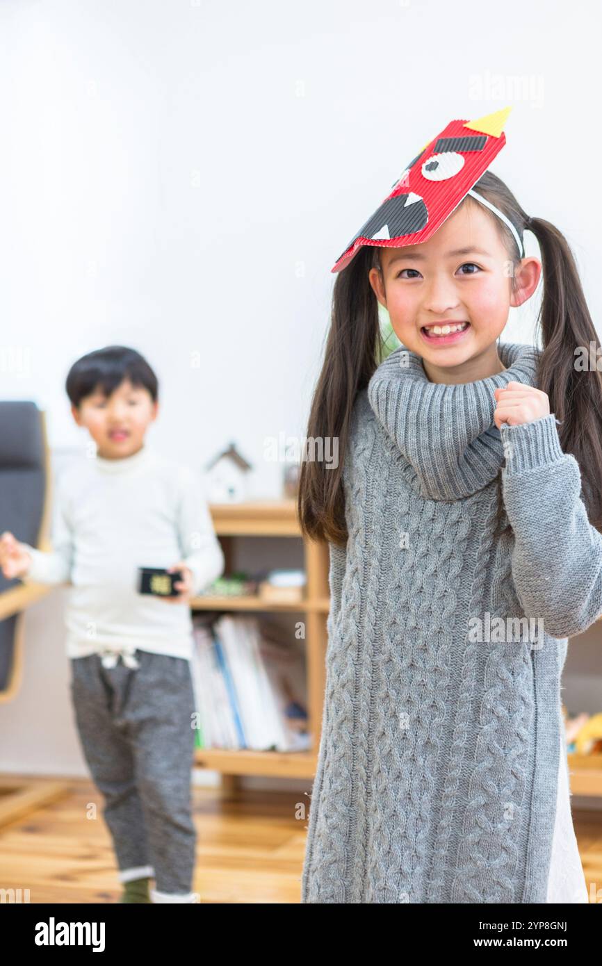 Sisters and brothers throwing beans for Setsubun Stock Photo - Alamy