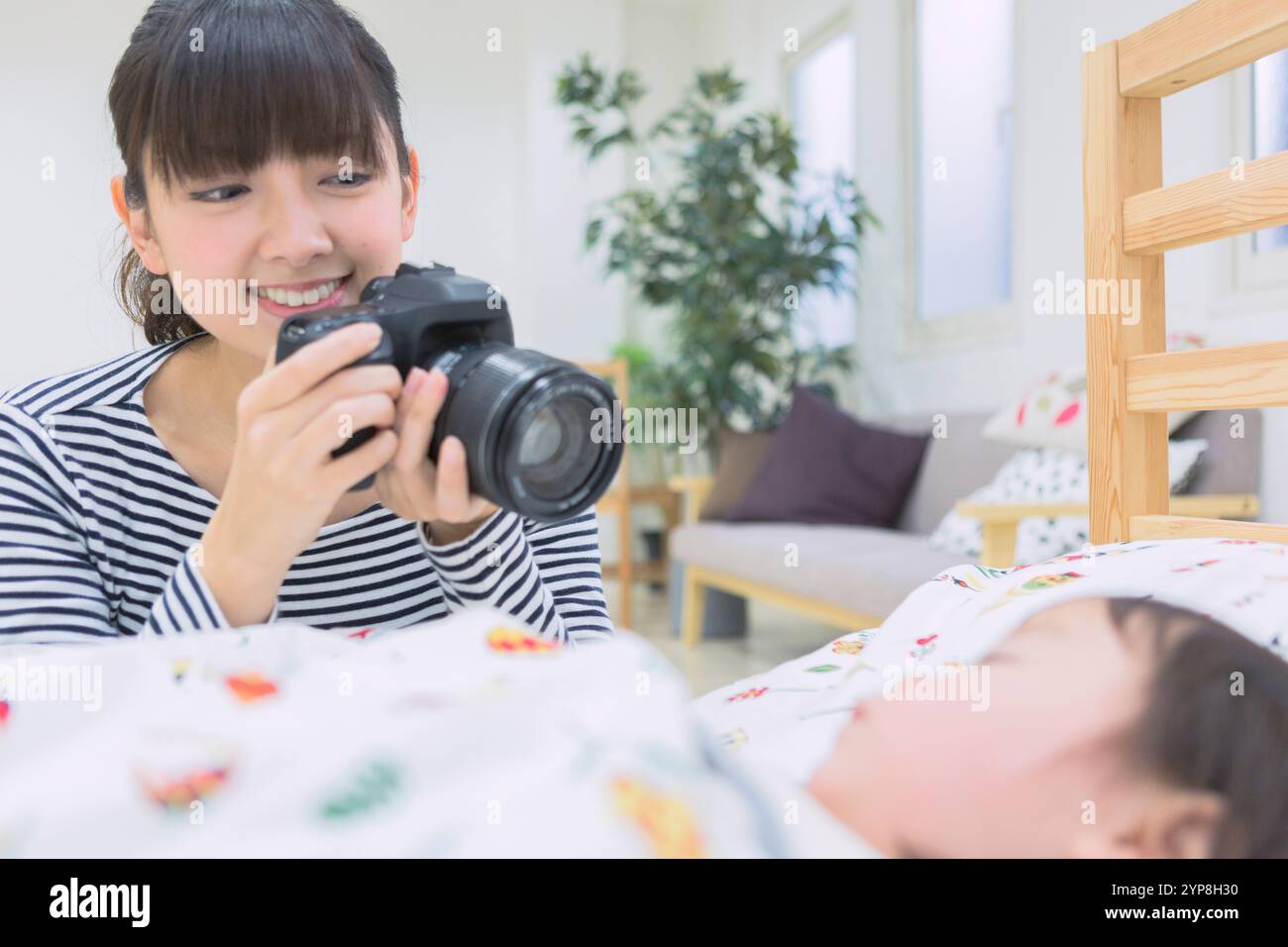 Mother filming sleeping child Stock Photo - Alamy