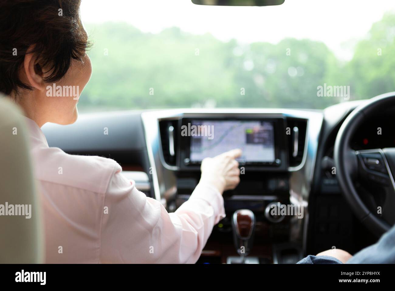 Senior woman operating car navigation system Stock Photo - Alamy