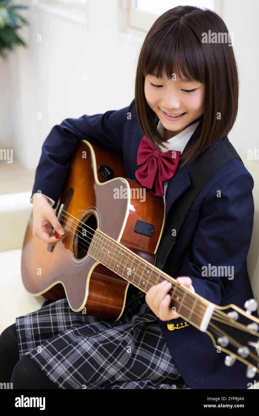 Junior high school student playing guitar Stock Photo - Alamy
