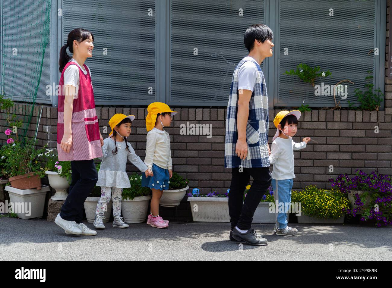 Nursery school teacher and children taking a walk Stock Photo - Alamy