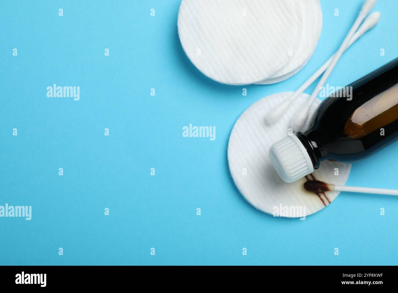 Topical iodine, cotton pads and swabs on light blue background, flat ...