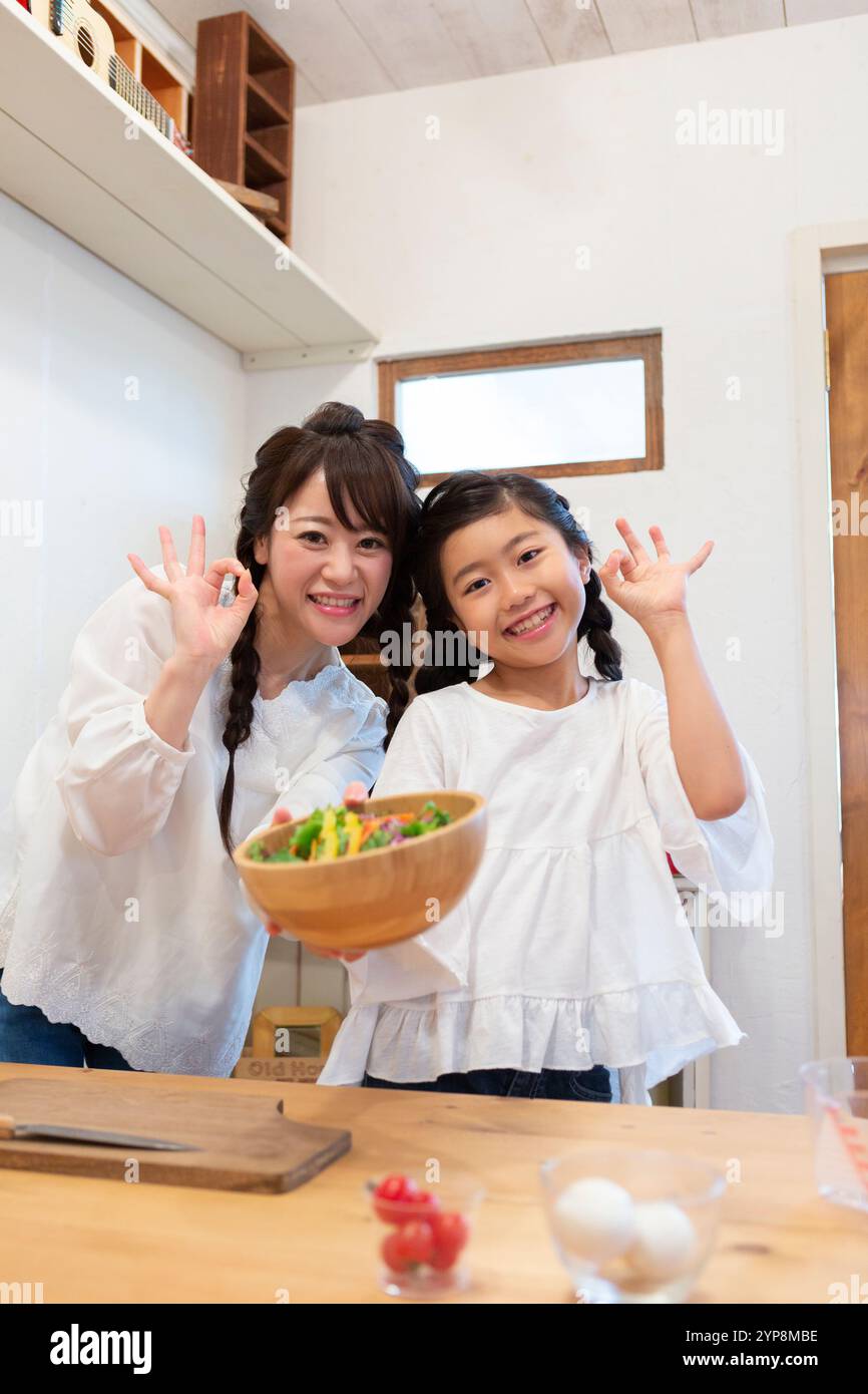 Mother and daughter holding salad bowls Stock Photo - Alamy