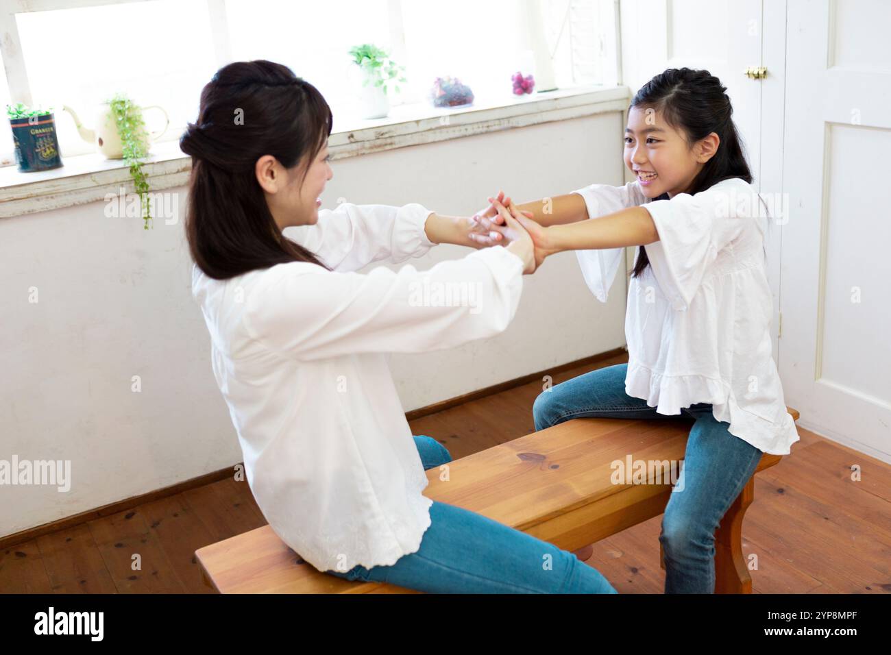 Parent and child playing astride bench Stock Photo - Alamy