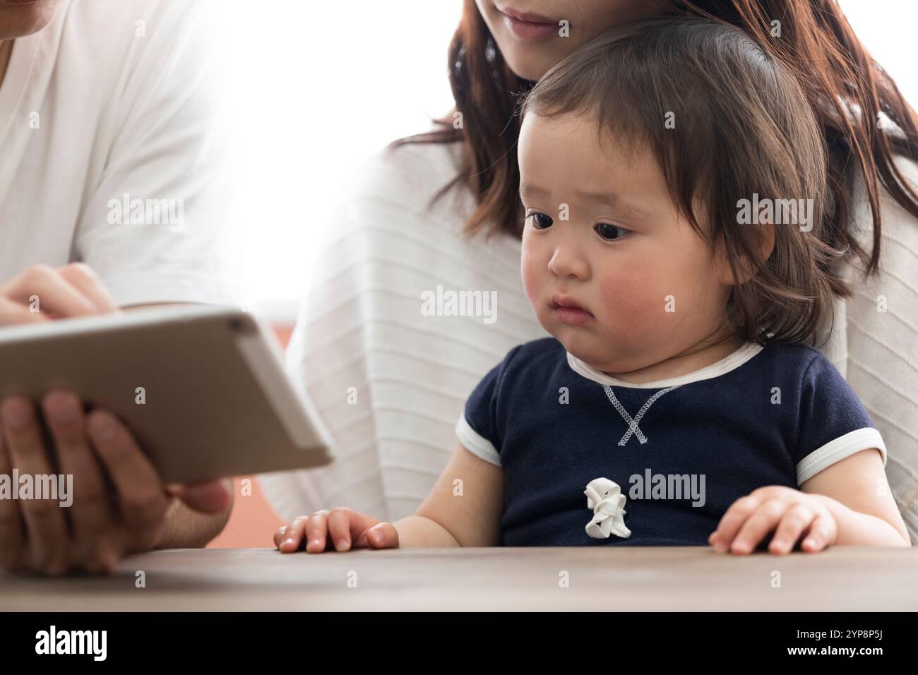 Parents showing tablet to child Stock Photo - Alamy