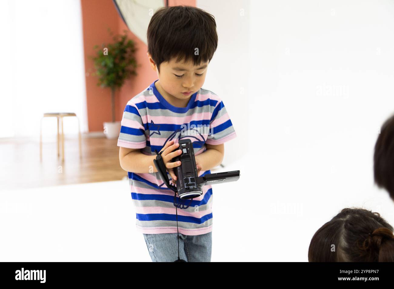 Boy rolling video camera Stock Photo - Alamy