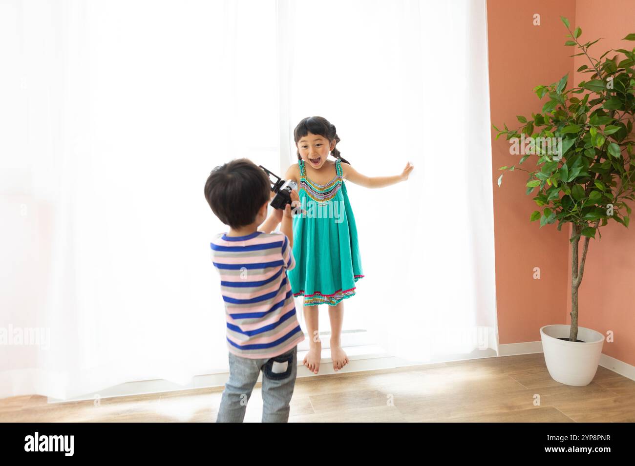 Boy rolling video camera and girl modelling Stock Photo - Alamy