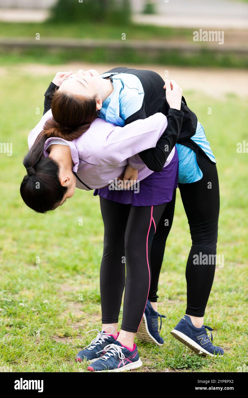 Two women doing back stretches Stock Photo - Alamy