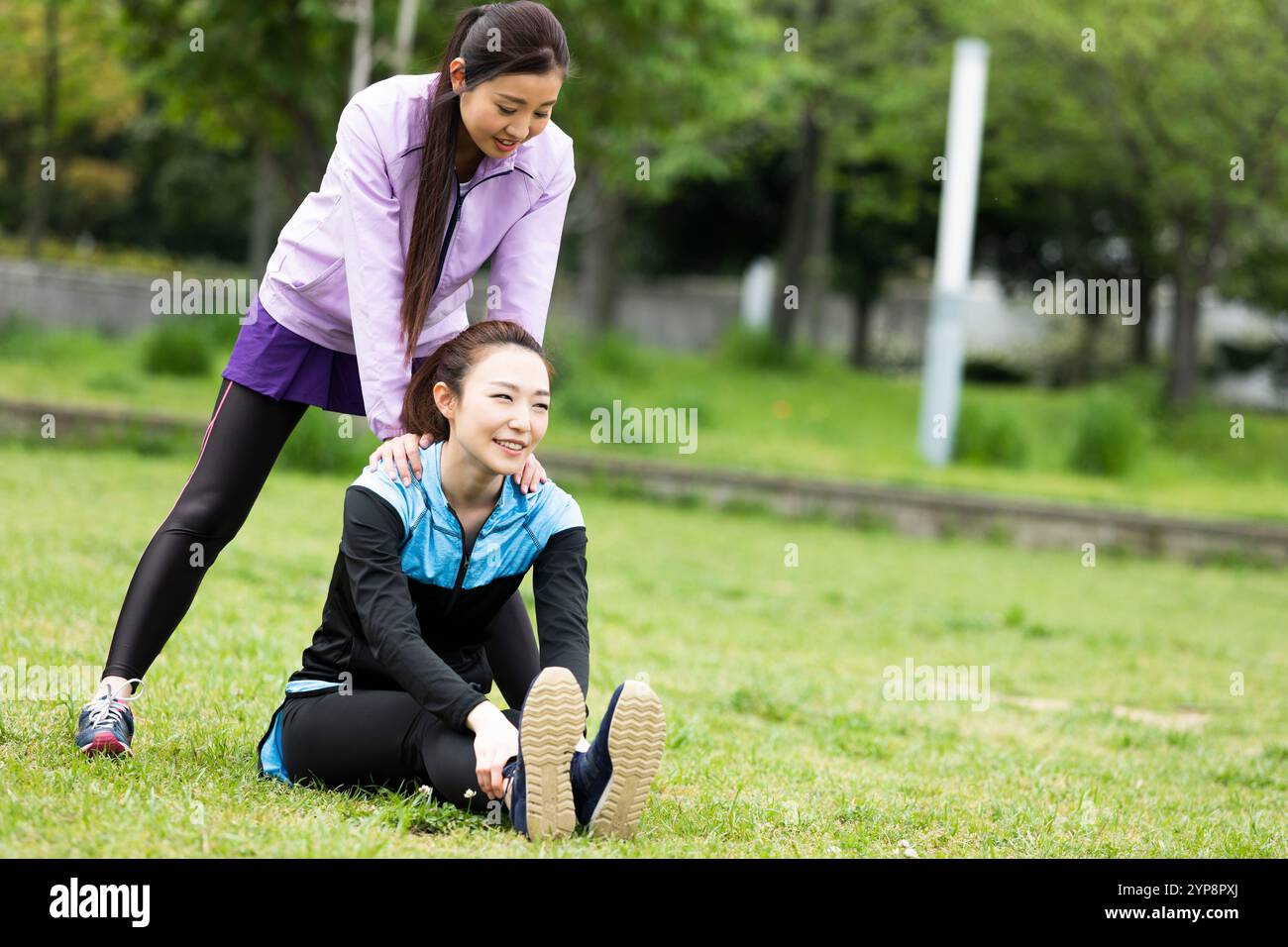 Two women stretching Stock Photo - Alamy