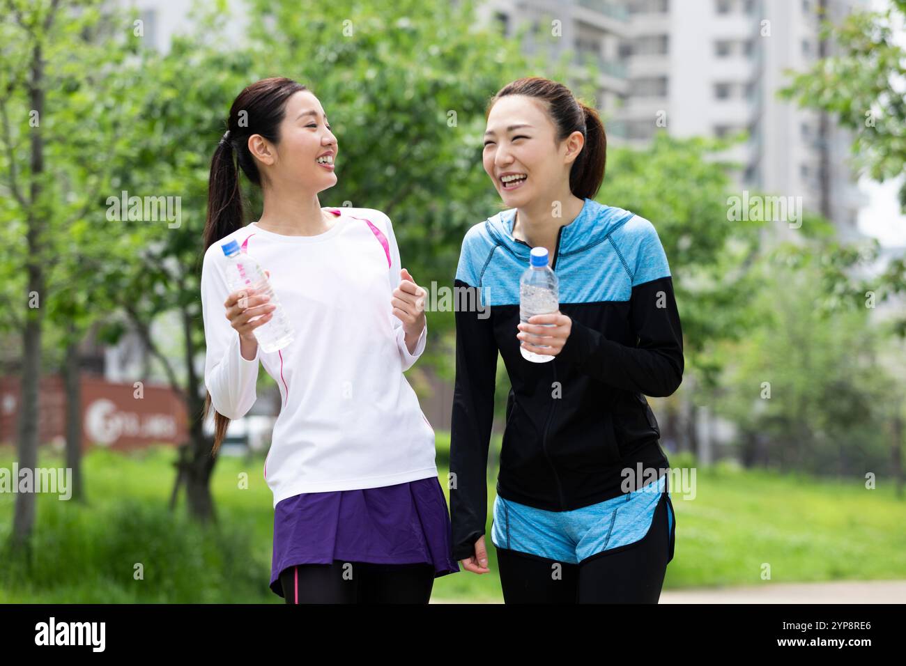 Two women walking with water Stock Photo - Alamy