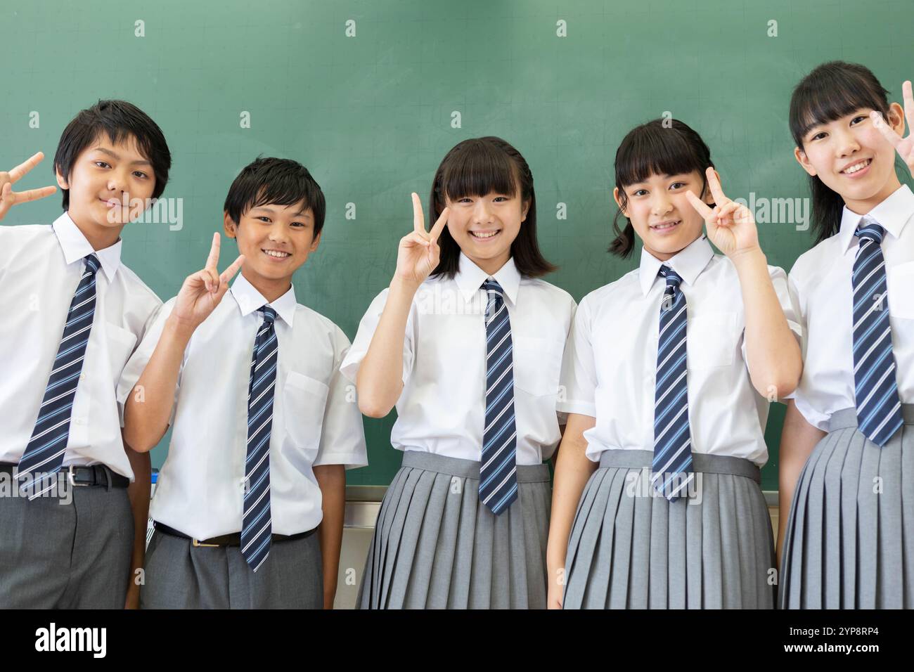Junior high school students lined up in front of blackboard Stock Photo ...