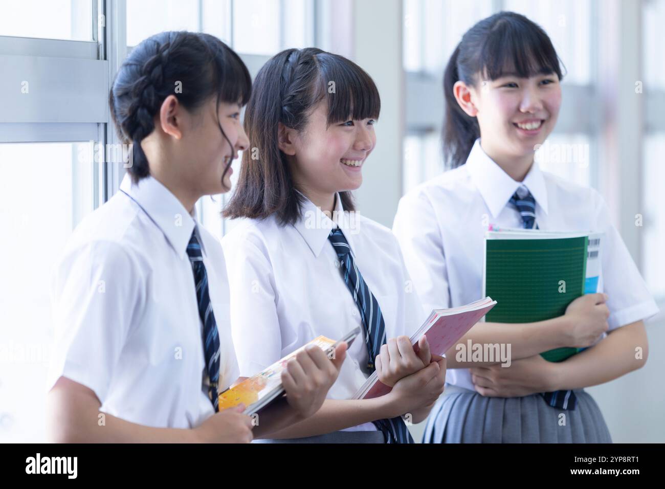 Junior high school students chatting in the corridor Stock Photo - Alamy